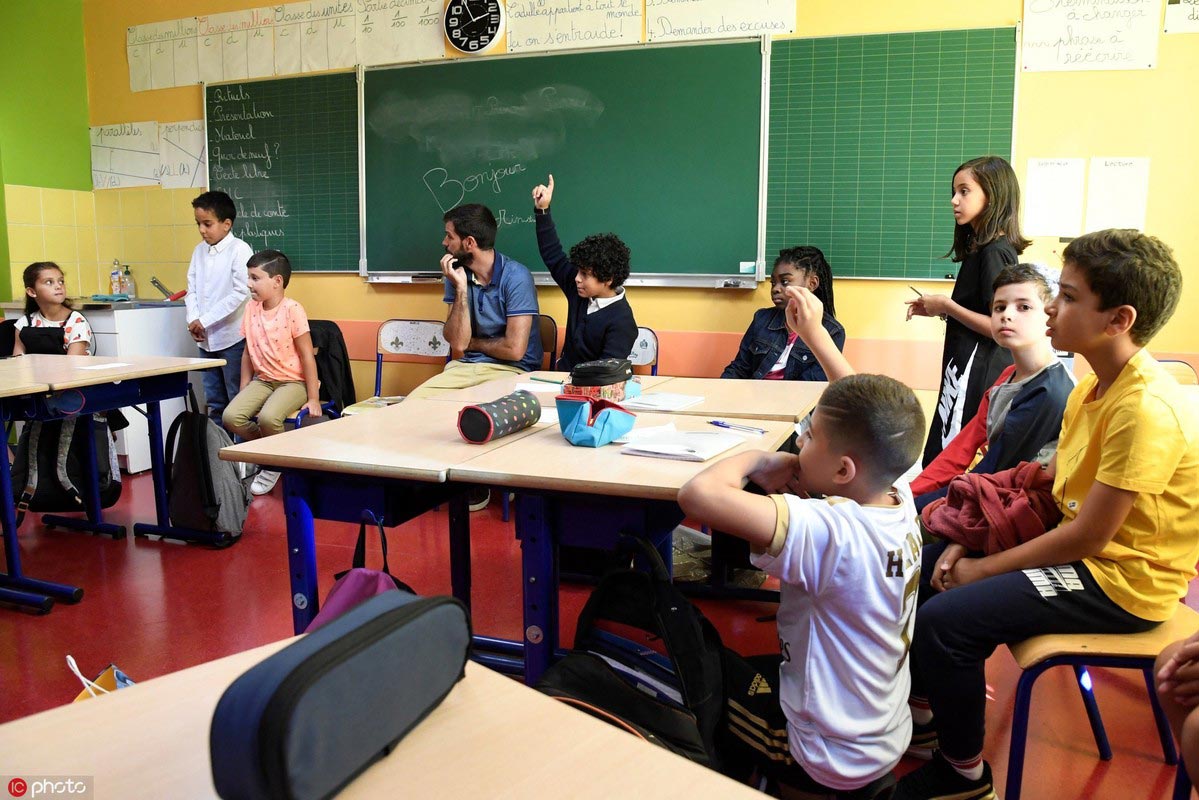 Why do schools in France to display flags in classrooms?